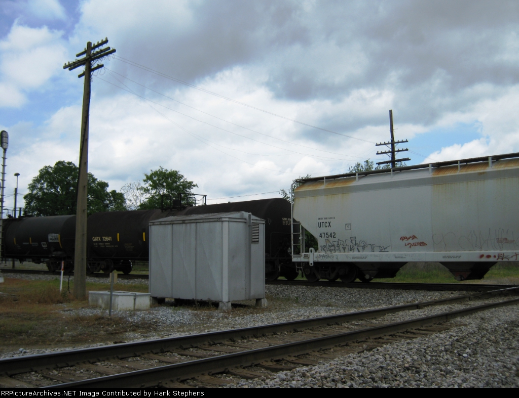Shot of NS 336 cars passing diamond interlocking relay house and over CSX AWP-WofA main at Opelika.